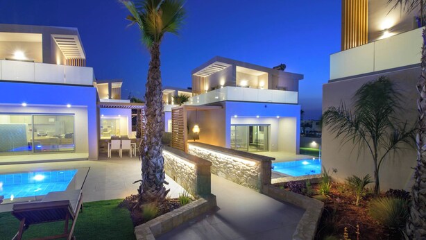 Uma casa moderna de vários andares, com piscina, área de estar externa e varandas bem iluminadas.
