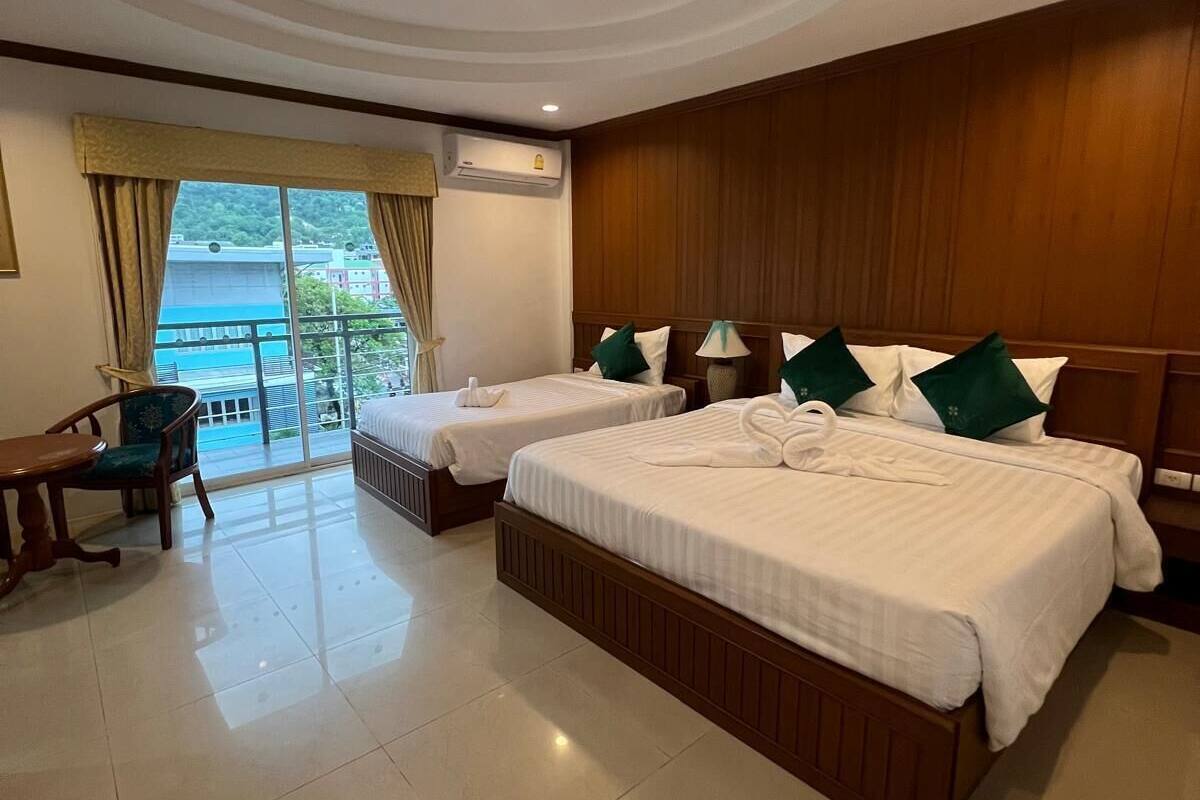 Quarto de hotel com duas camas, uma escrivaninha e uma cadeira.