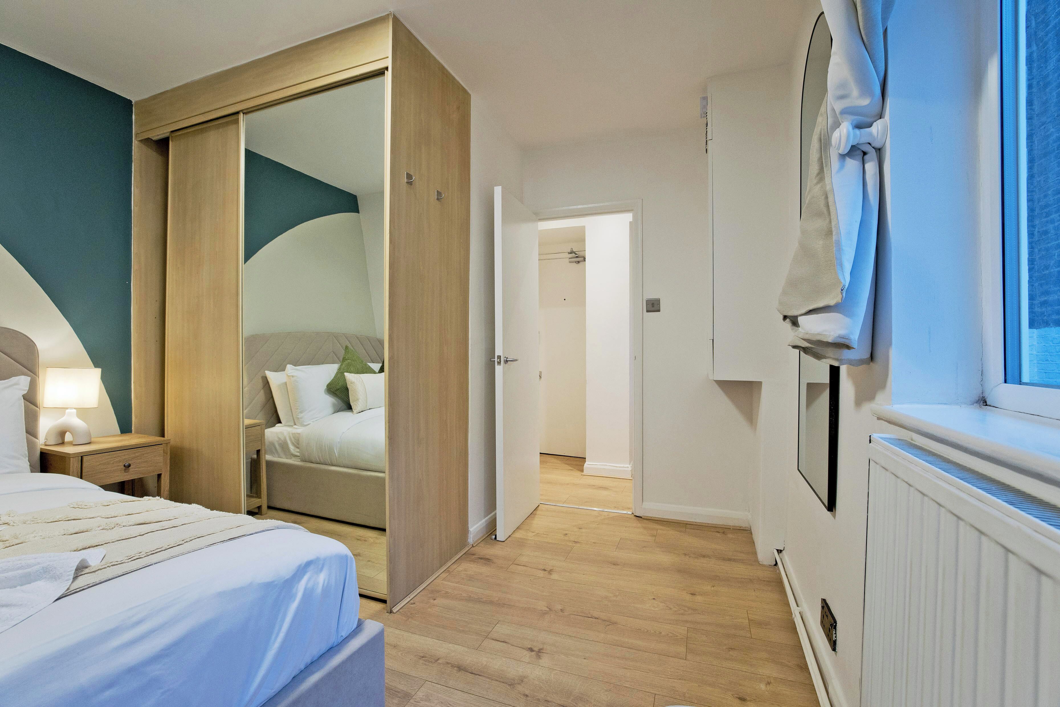 Quarto com cama, mesa de cabeceira e guarda-roupa.