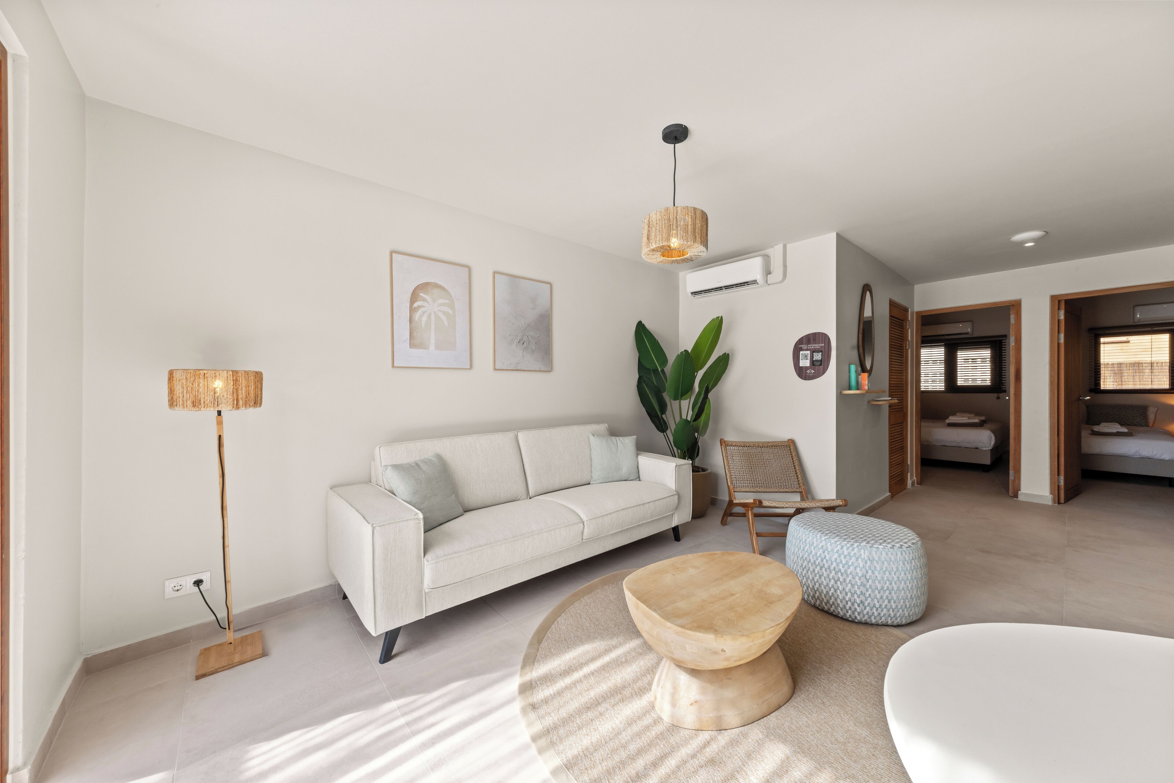 Uma sala de estar moderna com sofá, mesa de centro, abajur e planta em vaso.