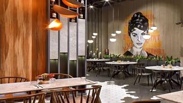 Interior de restaurante com paredes de madeira, luminárias pendentes e um mural na parede do fundo.