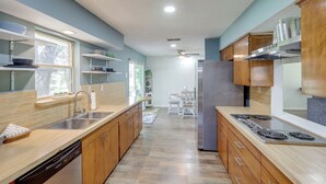 Uma cozinha moderna com armários de madeira, eletrodomésticos de aço inoxidável e uma janela grande que traz luz natural.