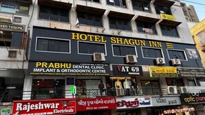 Um edifício de vários andares com uma placa indicando Hotel Shagun Inn.