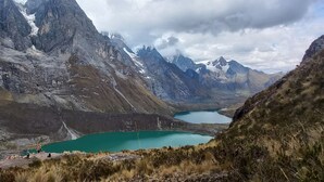 Paisagem montanhosa com um lago e terreno rochoso.