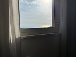 Janela com vista para o céu e paisagem distante.