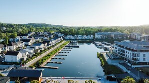 Zona residencial à beira-rio com casas modernas, um porto de iates e um restaurante.