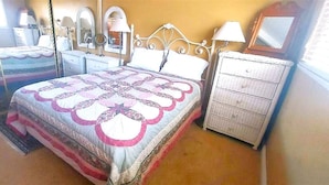 Quarto com duas camas, uma cômoda e um espelho.