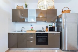 Um frigorífico, um micro-ondas, um forno, uma placa de cozinha 