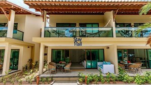Um hotel com placa 'Stay Hall', área de estar ao ar livre e um pátio coberto.