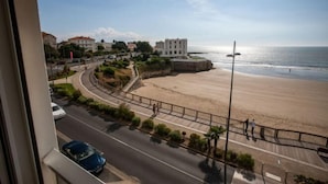Uma estrada costeira com uma praia e edifícios ao fundo.