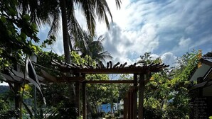 Uma trilha que serpenteia por um jardim com estrutura de pérgola.