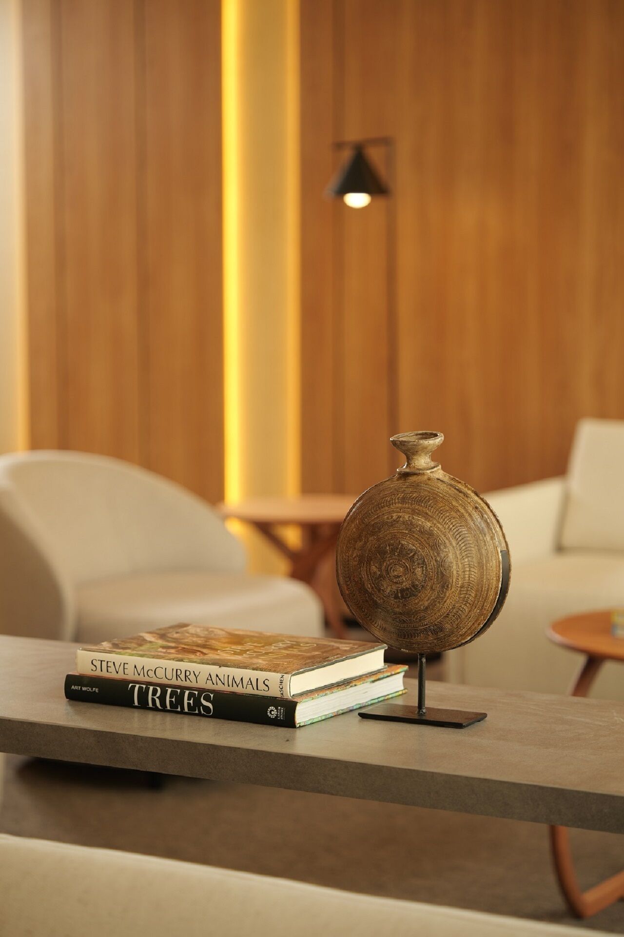 Um livro chamado 'Trees' sobre uma mesa com um vaso decorativo.