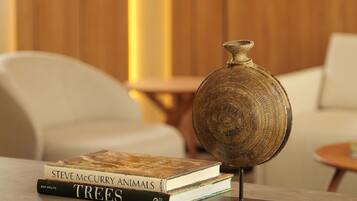 Um livro chamado 'Trees' sobre uma mesa com um vaso decorativo.