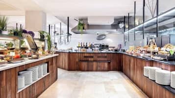 Cozinha moderna com bancada de madeira, eletrodomésticos de aço inoxidável e diversos alimentos à mostra.