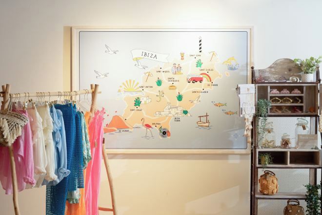 Quarto com mapa de Ibiza, um cabideiro e uma estante com diversos objetos.