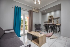 Uma sala moderna com um sofá, uma mesa de centro e uma área de jantar com uma escada e banquetas.