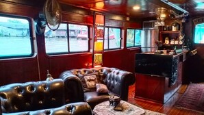 Um interior acolhedor com sofás de couro, uma mesa pequena e um espaço de bar com televisão.