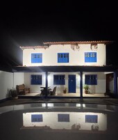 Um edifício de dois andares com janelas emolduradas em azul e telhado com telhas.