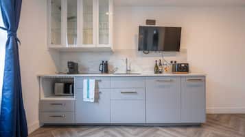 Um frigorífico/congelador grande, um micro-ondas, uma placa de cozinha