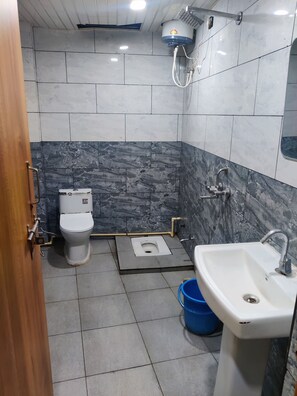 Uma casa de banho compacta com sanita, bidé e lavatório.