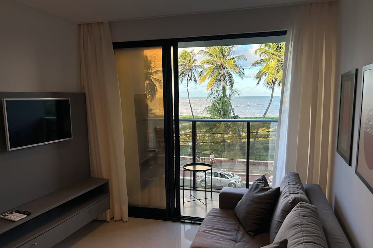 Apartamento luxo, 2 quartos, varanda, de frente para a praia | Sala de estar | Smart TV 32 polegadas com canais a cabo