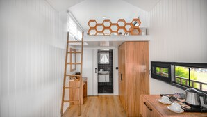 Cozinha compacta com bancada de madeira, pia e janela com vista.