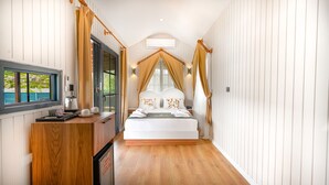 Quarto pequeno com uma cama, uma escrivaninha e uma televisão.