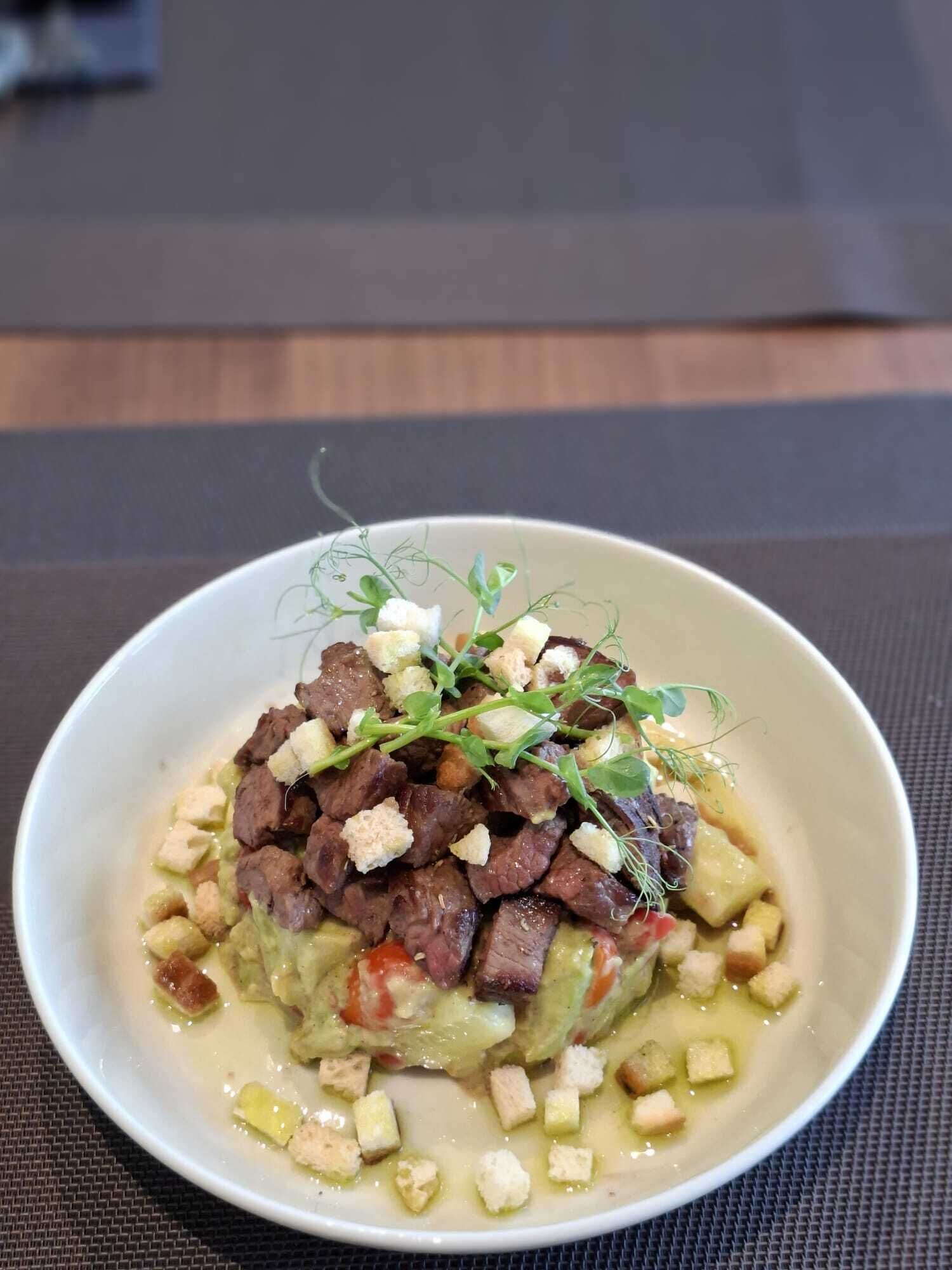Uma tigela de comida com croutons e folhas.