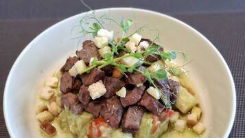 Uma tigela de comida com croutons e folhas.
