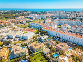 Uma área residencial costeira com vários edifícios de apartamentos, alguns com piscinas no terraço.