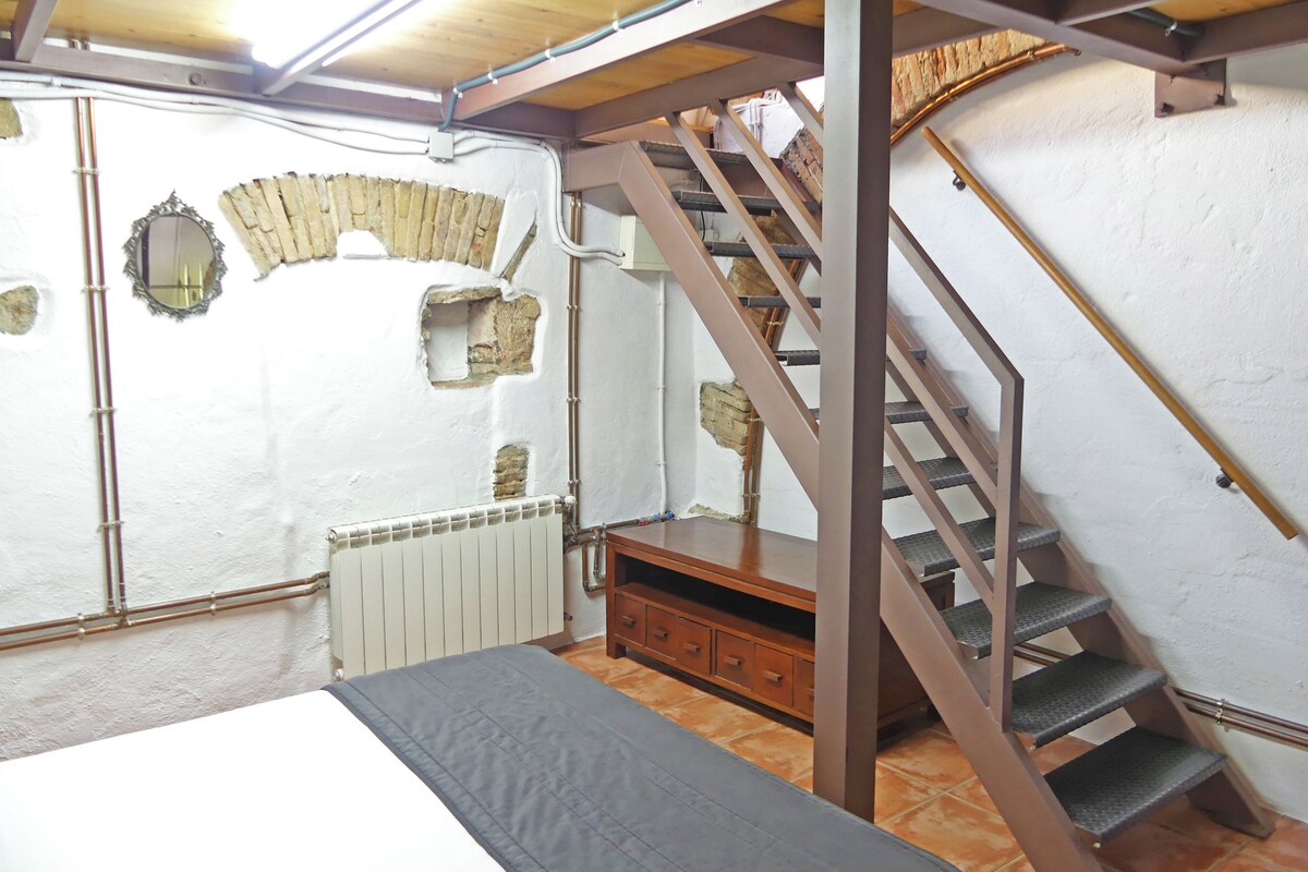 Quarto com escada de madeira, radiador e cama.