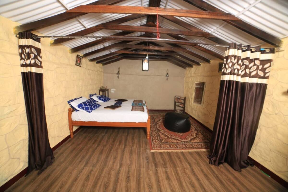 Um quarto pequeno e acolhedor com cama de madeira, tapete e cortinas.