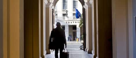 Um corredor com arcos que levam à entrada de um edifício.