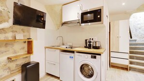 Uma cozinha compacta equipada com micro-ondas, forno e máquina de lavar.