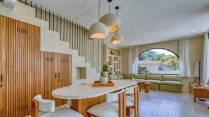 Uma cozinha moderna com ilha central, armários de madeira e iluminação pendente.
