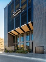 Um edifício moderno com uma placa de destaque com a inscrição "ONE SHARQ".