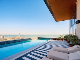 Piscina no terraço com vista para a cidade e para o mar.