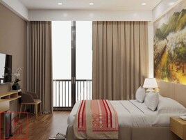 Quarto de hotel moderno com uma cama grande, uma escrivaninha, uma cadeira, uma televisão e uma varanda com cortinas.