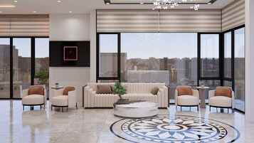 Uma sala de estar moderna com uma janela grande, um sofá, poltronas, uma mesa de centro e um padrão decorativo no chão.