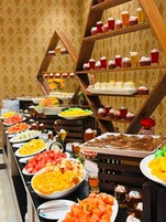 Buffet com diversas frutas, sobremesas e bebidas.
