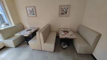 Quarto nos fundos com sofá, mesa pequena e lixeira.