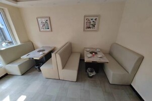 Quarto nos fundos com sofá, mesa pequena e lixeira.