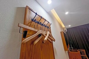 Uma porta de madeira com um porta-casacos e um porta-toalhas fixado na parede.