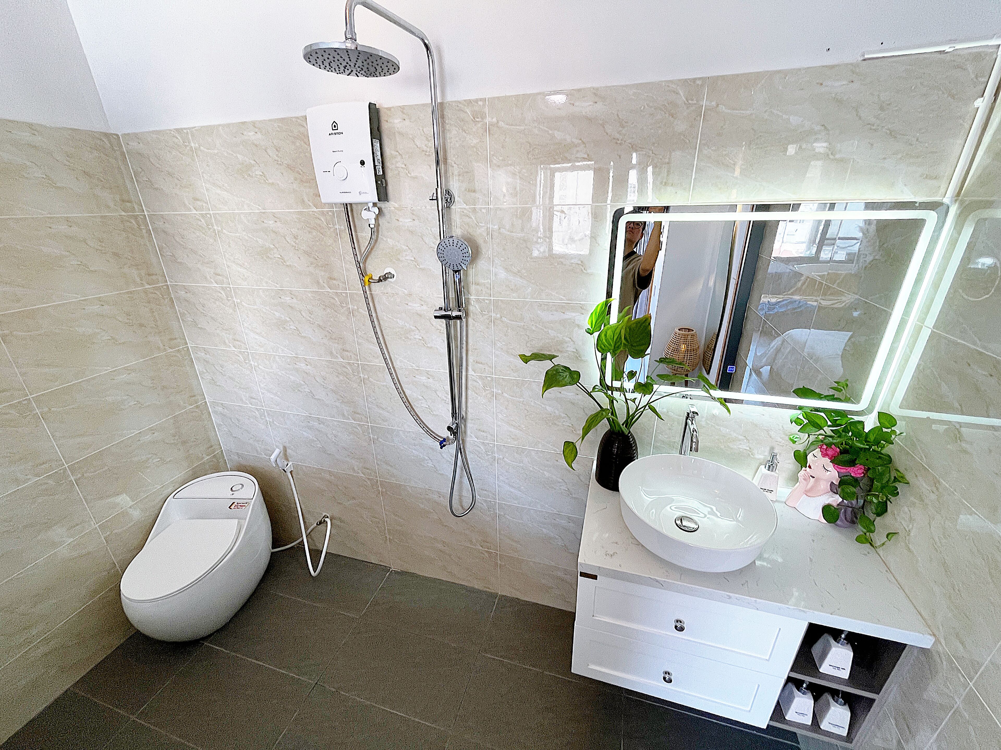 Casa de banho moderna com sanita, lavatório e chuveiro.
