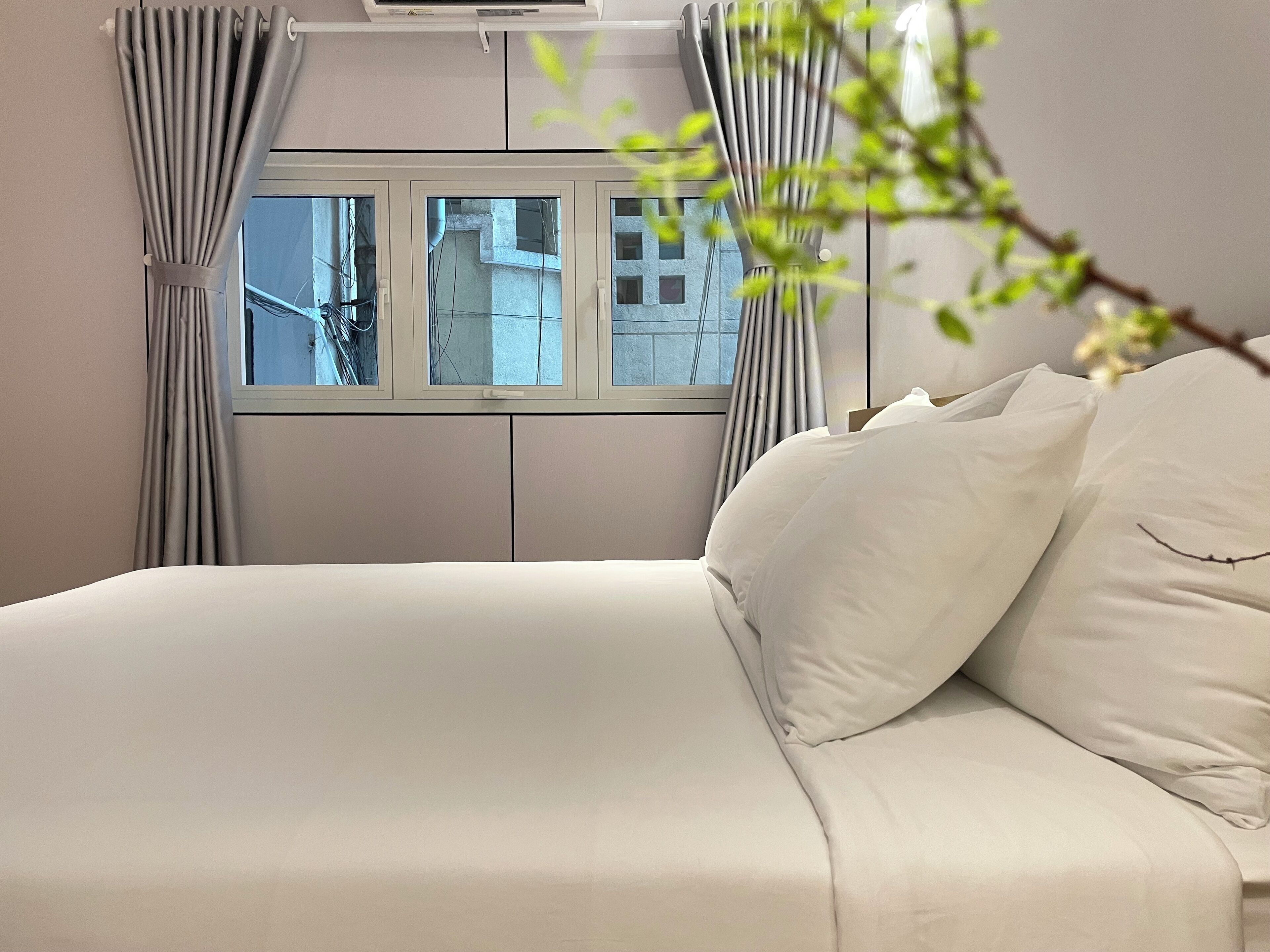 Quarto com cama, cortinas e janela.
