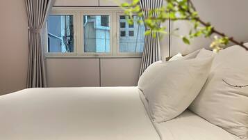 Quarto com cama, cortinas e janela.
