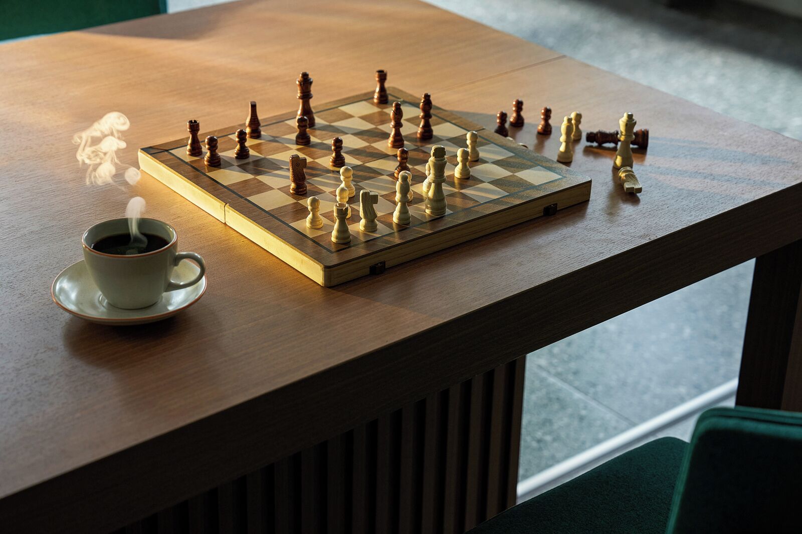 Um tabuleiro de xadrez sobre uma mesa de madeira, com uma chávena de café ao lado.