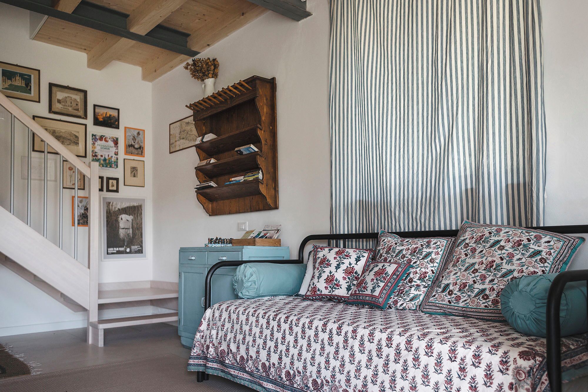 Um quarto acolhedor com uma cama, uma estante de madeira e uma escada.