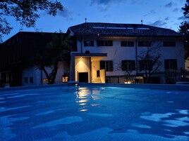 Um edifício com piscina ao entardecer.
