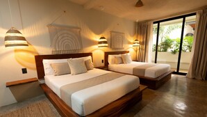 Quarto de hotel com duas camas, uma janela grande com cortinas e luminárias fixadas na parede.